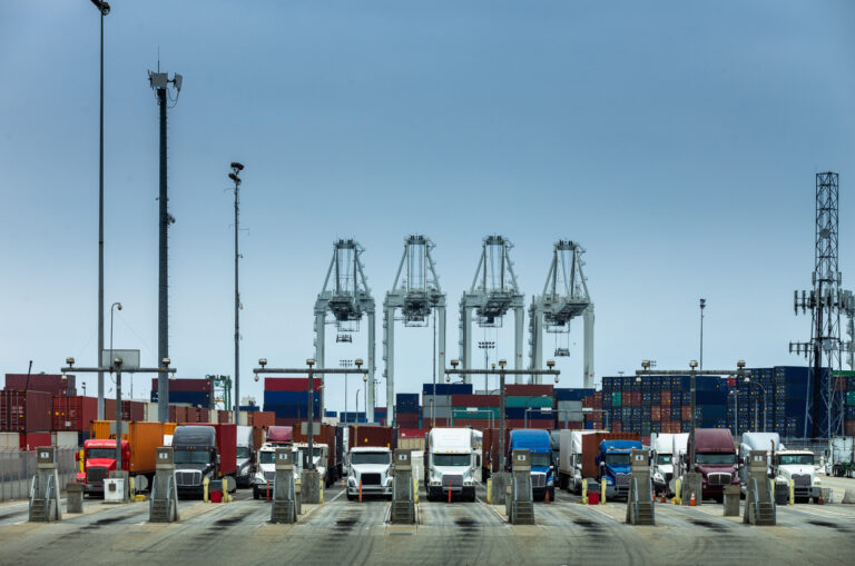Line of Trucks Beneath Ship to Shore Cranes at Container Terminal ...
